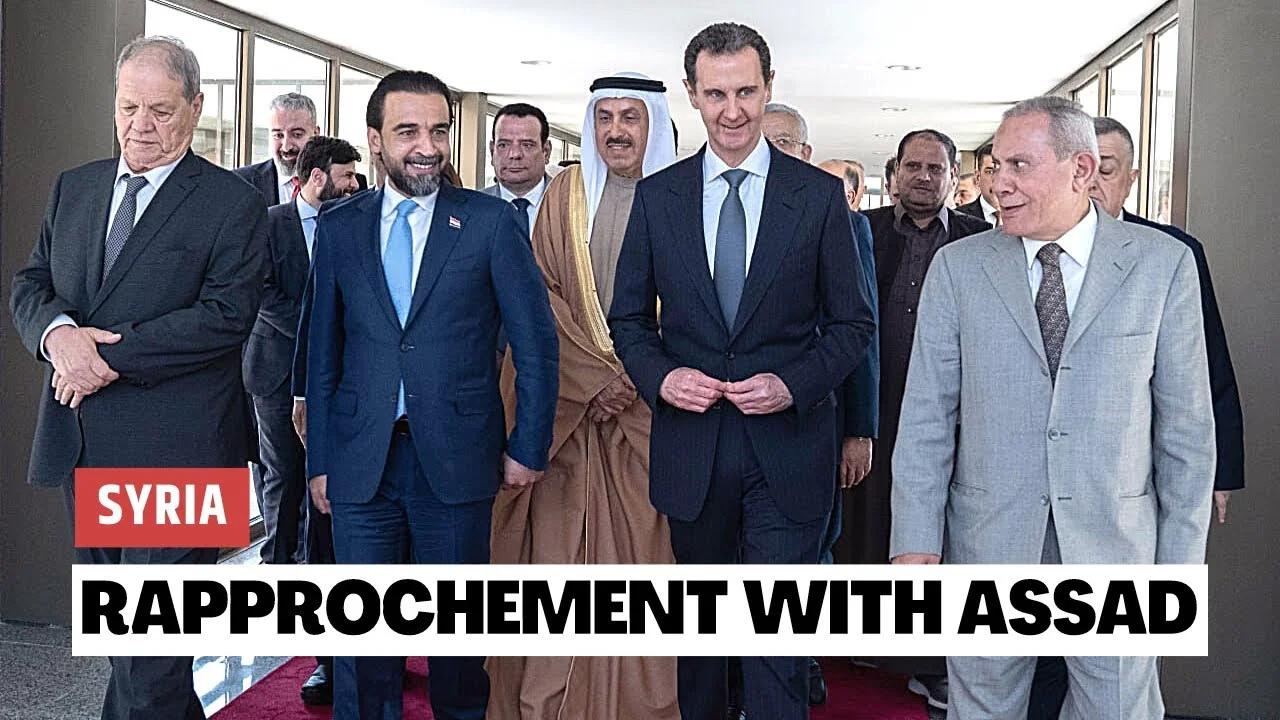 Arab officials stand in turn to shake hands with Bashar al-Assad