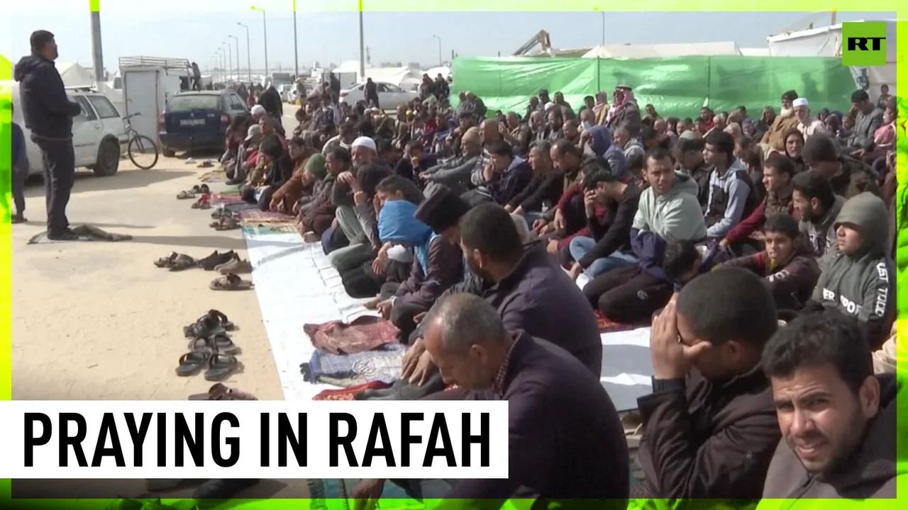 Displaced Palestinians pray in Muwasi camp in Rafah
