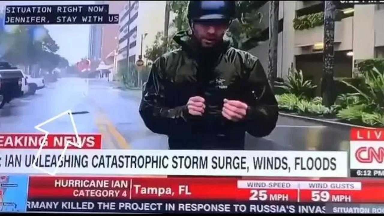 A Reporter pretending to be blown away as a man near the arrow walks ...